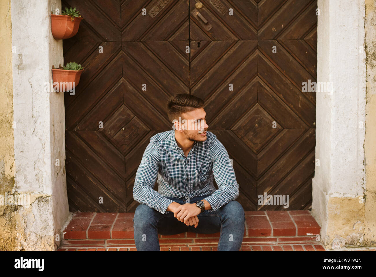 Young man sitting in a cafe, drinking coffee and talking on a mobile ...