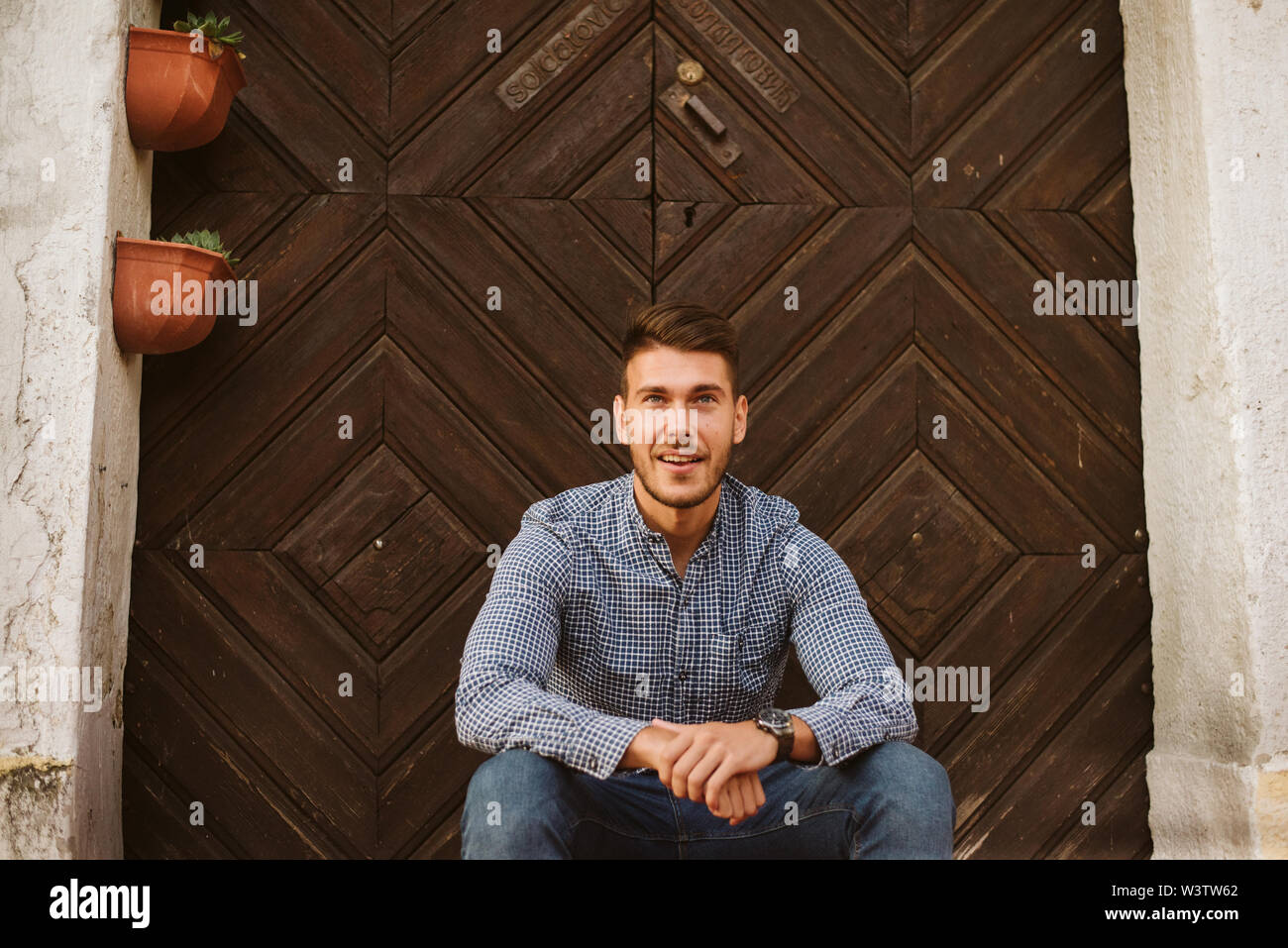 Young man sitting in a cafe, drinking coffee and talking on a mobile ...