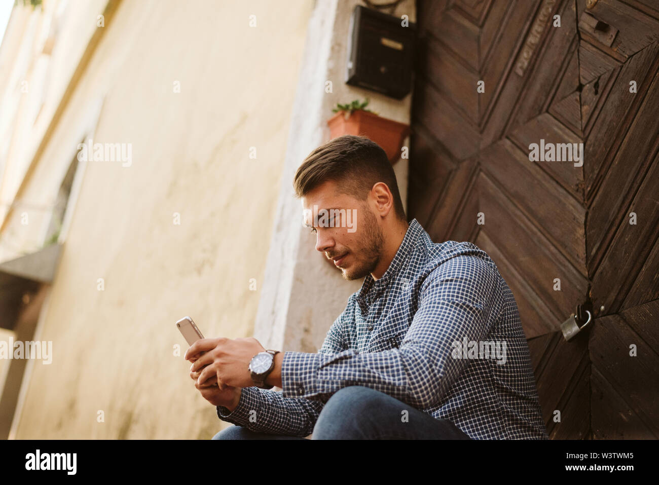 Young man sitting in a cafe, drinking coffee and talking on a mobile ...