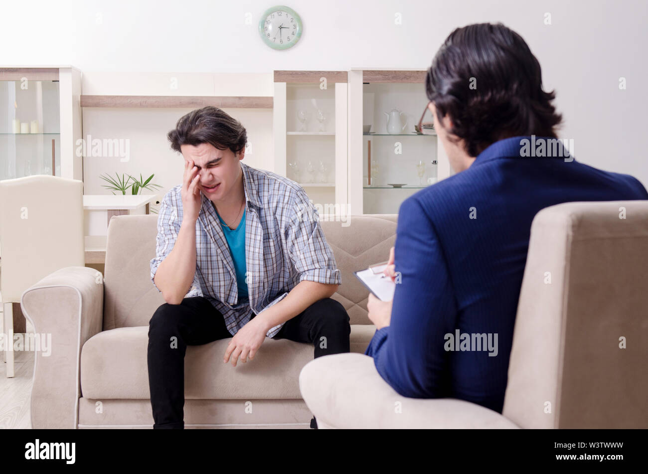 Young male patient discussing with psychologist personal problems Stock ...
