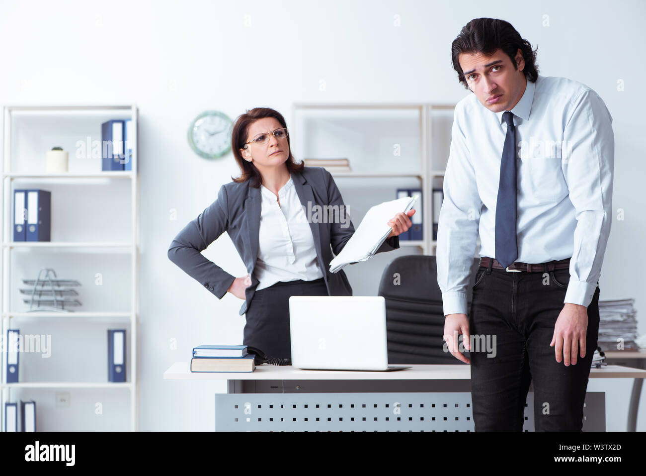 The old female boss and young male employee in the office Stock Photo ...