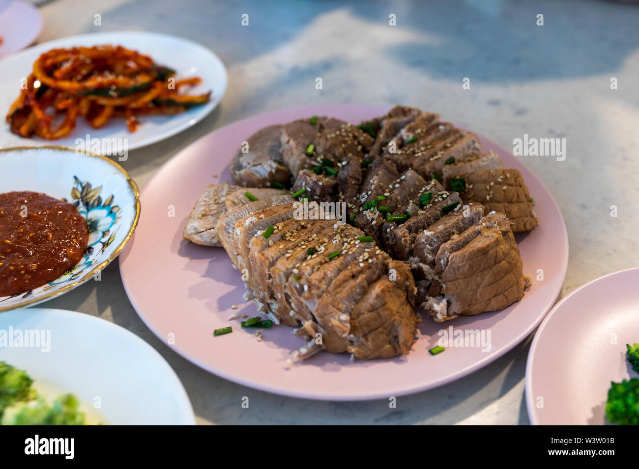 bossam, boiled pork eaten with a salty sauce and wrapped in greens ...