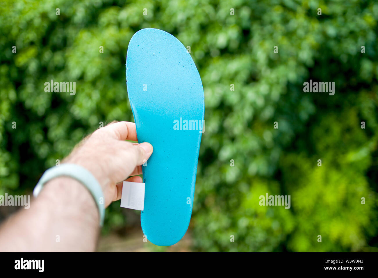 Man hand holding blue sport running shoe sole Stock Photo - Alamy