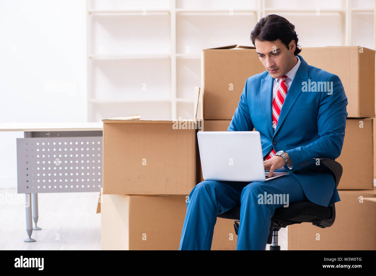 The young handsome businessman moving to new workplace Stock Photo - Alamy