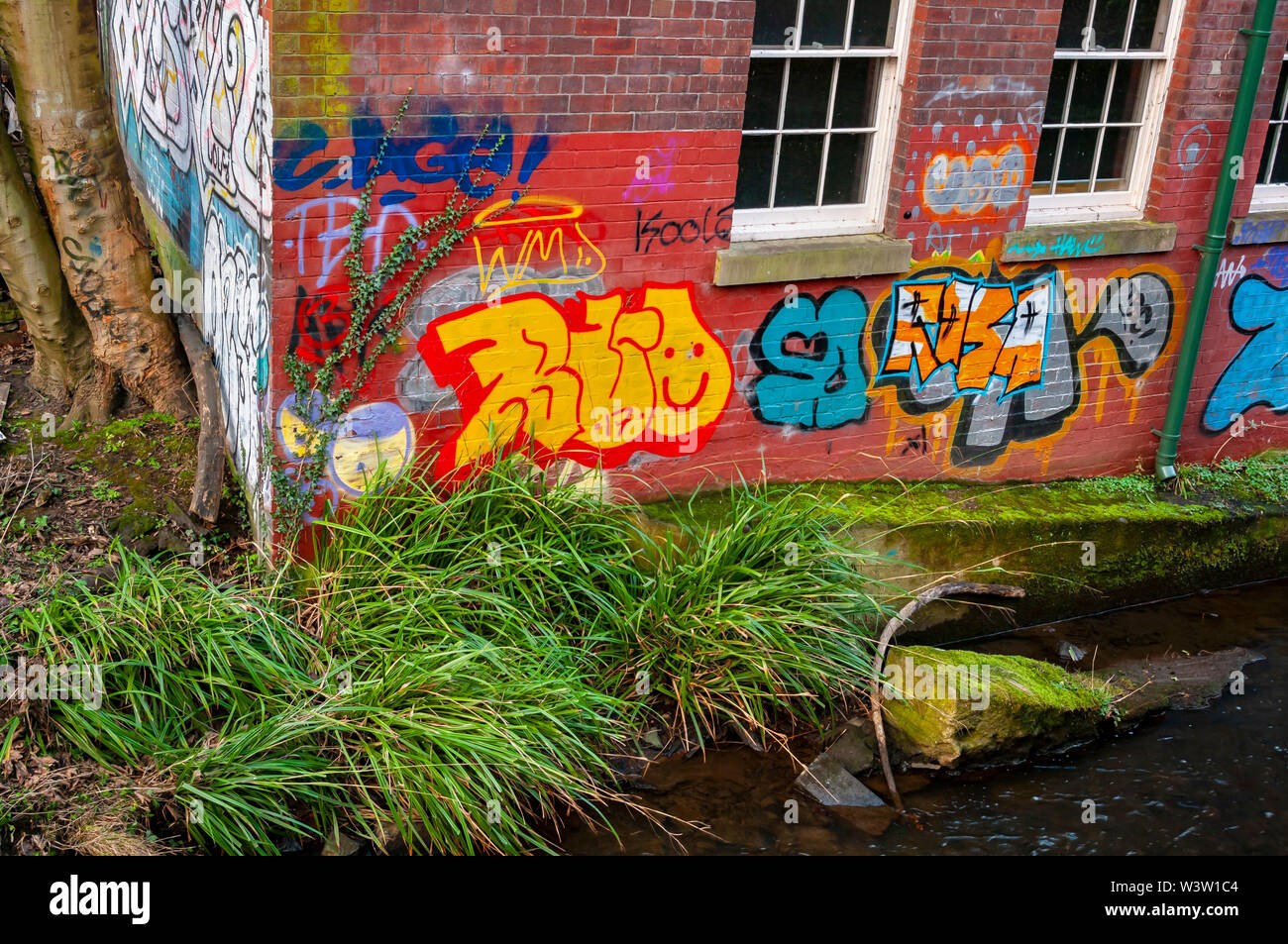Graffiti on the walls of a building by a stream in Sheffield, UK Stock ...