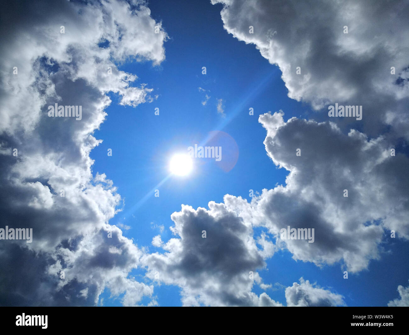 The sky with the sun and big white clouds Stock Photo - Alamy