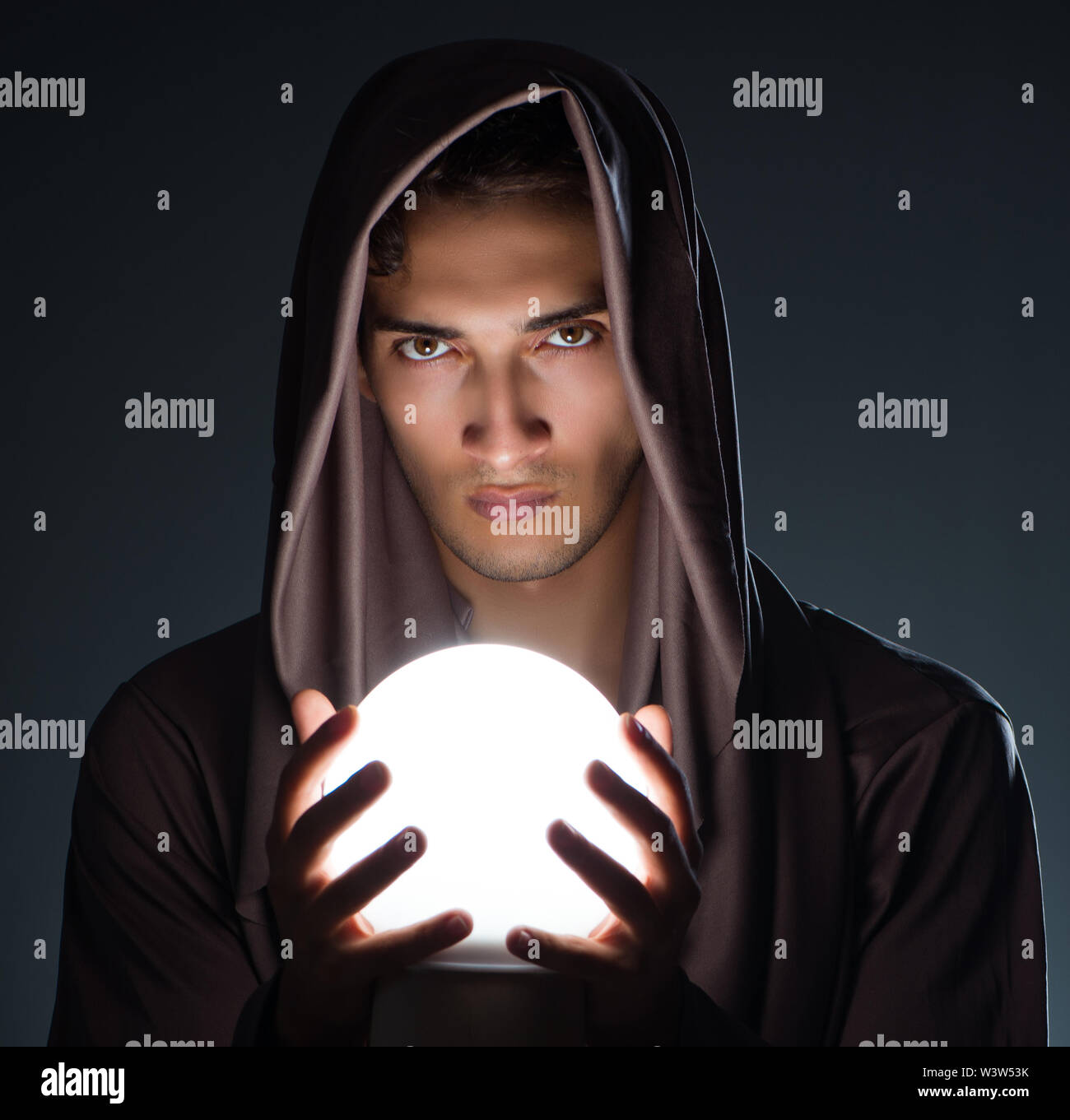 The young wizard with crystal ball in dark room Stock Photo - Alamy