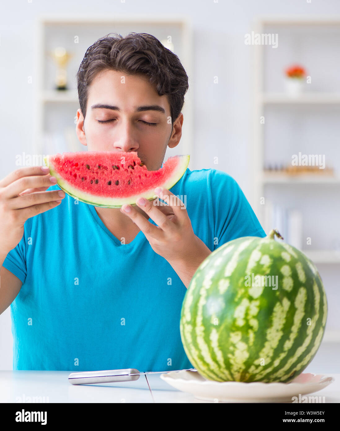 The man eating watermelon at home Stock Photo - Alamy