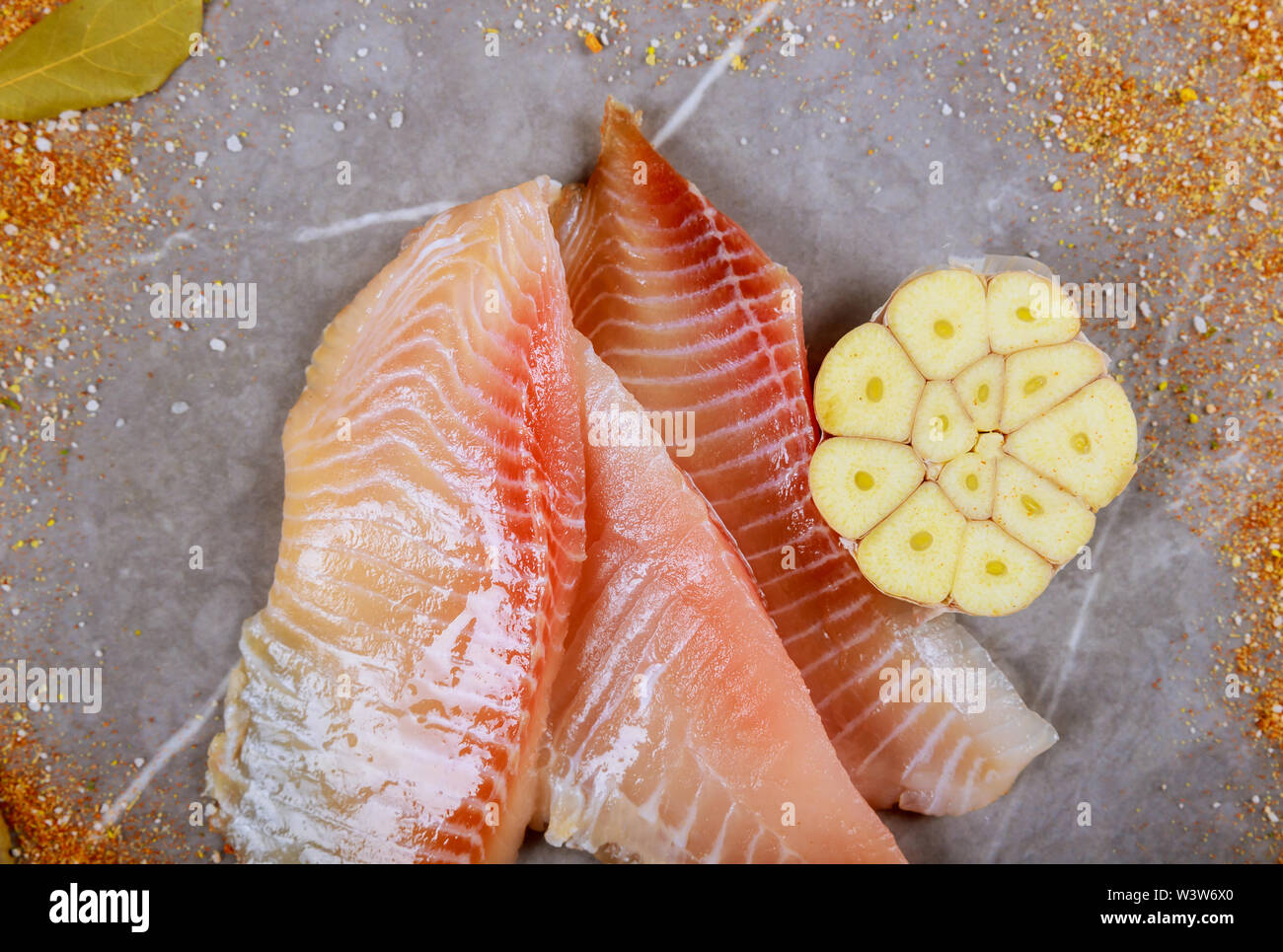 Tilapia raw fillets with spice, bay leaf on granite board Stock Photo ...