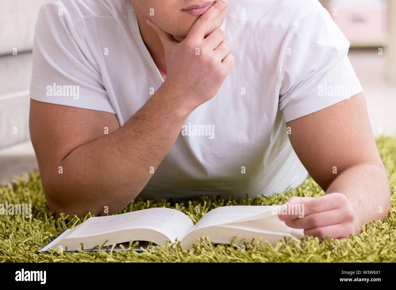 The man reading book at home on floor Stock Photo - Alamy