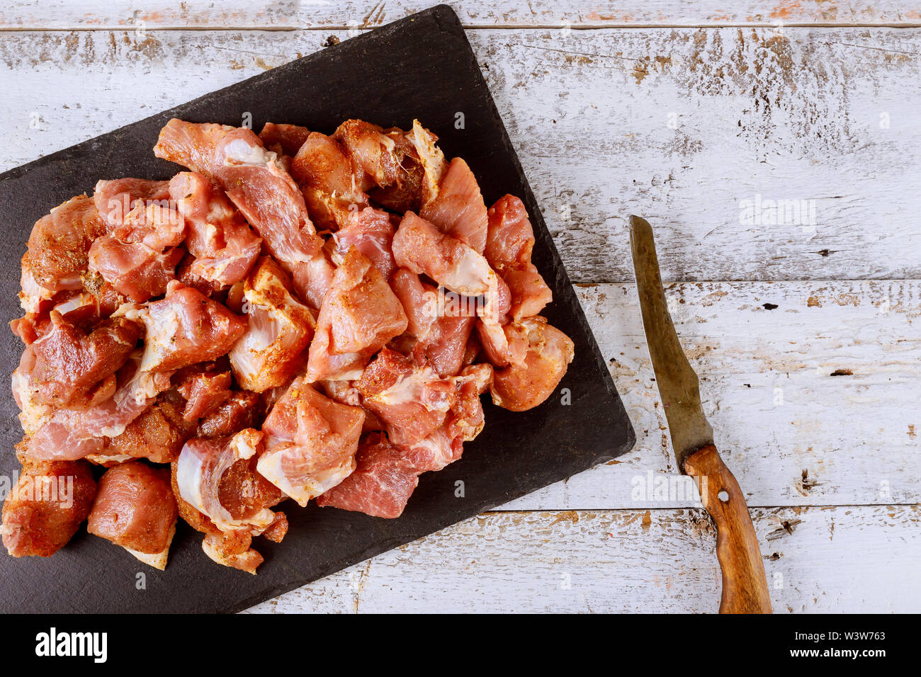 Cutted meat cubes on black board with knife Stock Photo - Alamy
