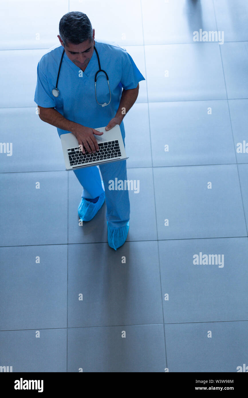 Male surgeon using laptop in the lobby of hospital Stock Photo - Alamy