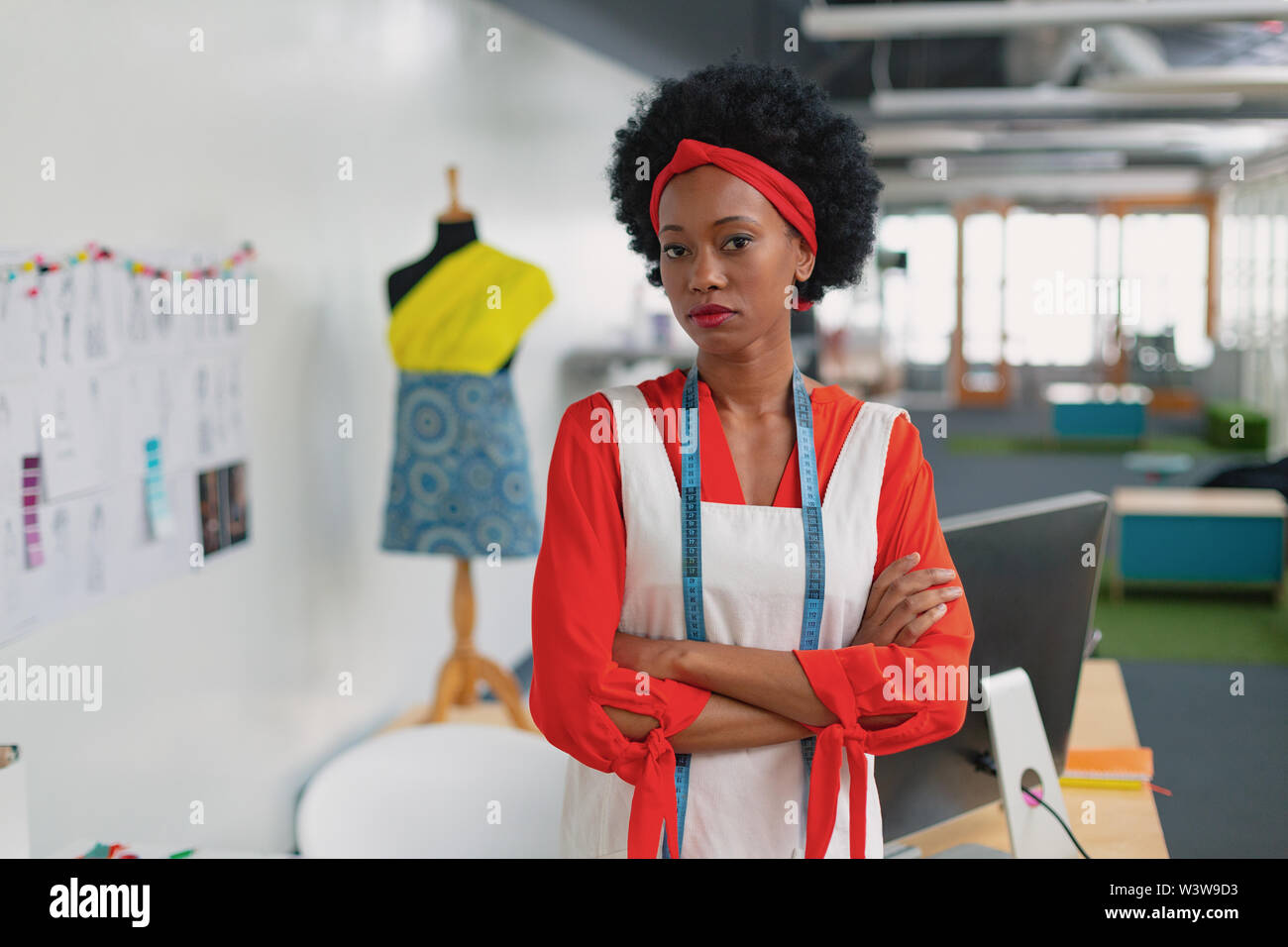 Female fashion designer standing with arms crossed in design studio ...