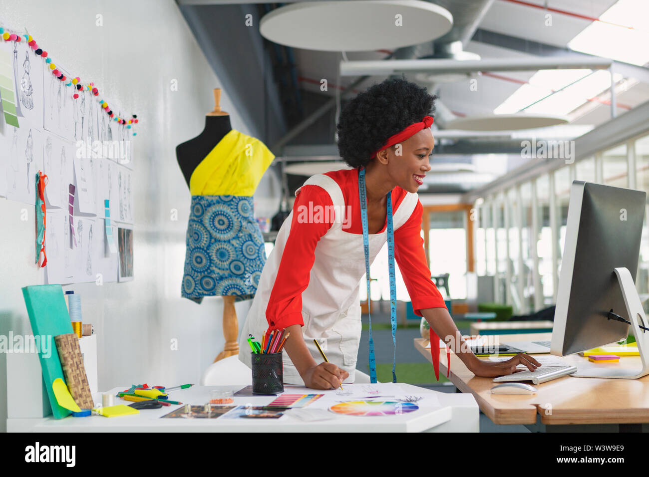 Female fashion designer drawing a sketch at desk Stock Photo - Alamy