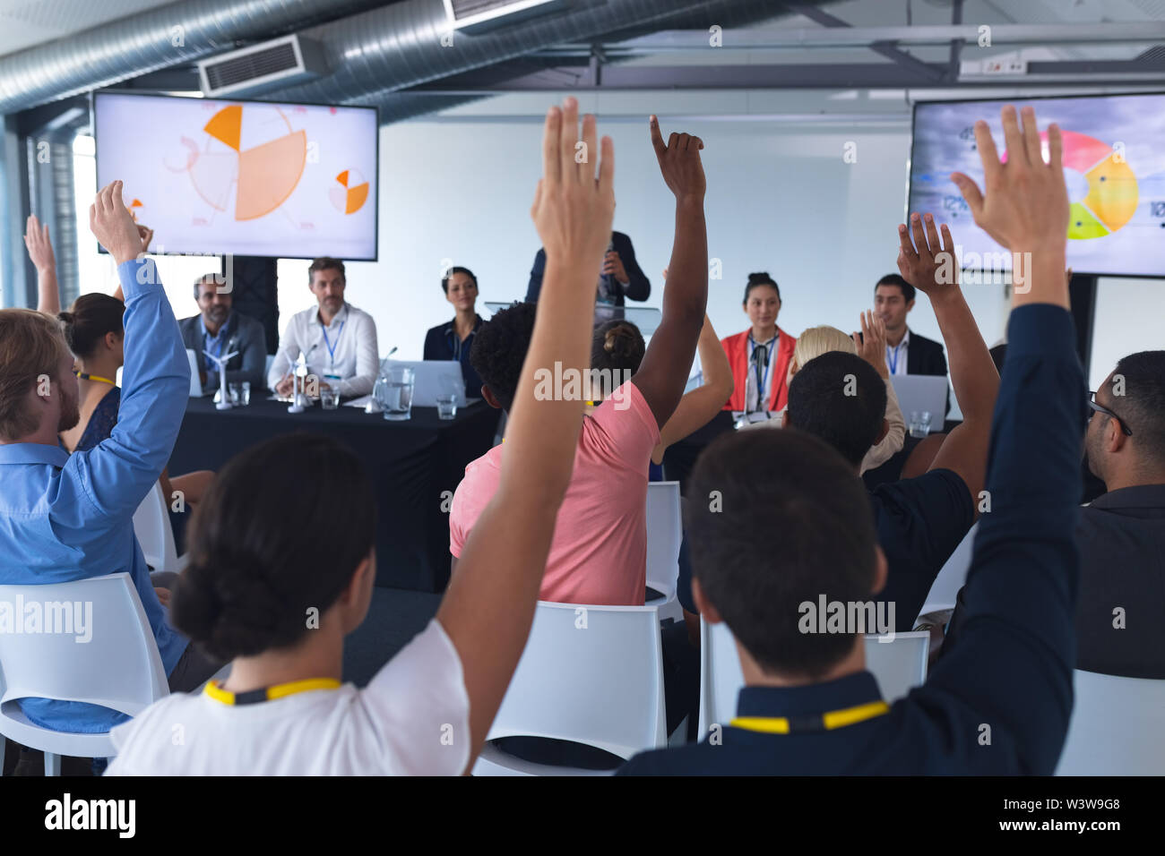 Audience raising their hands in a business conference Stock Photo - Alamy
