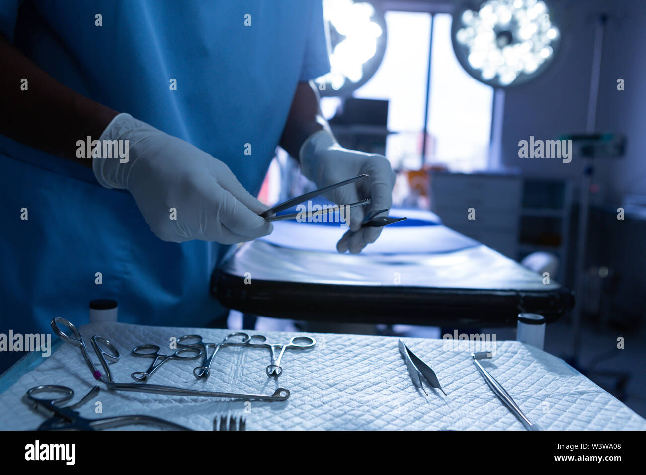Surgeon holding tweezers in operating room of hospital Stock Photo - Alamy