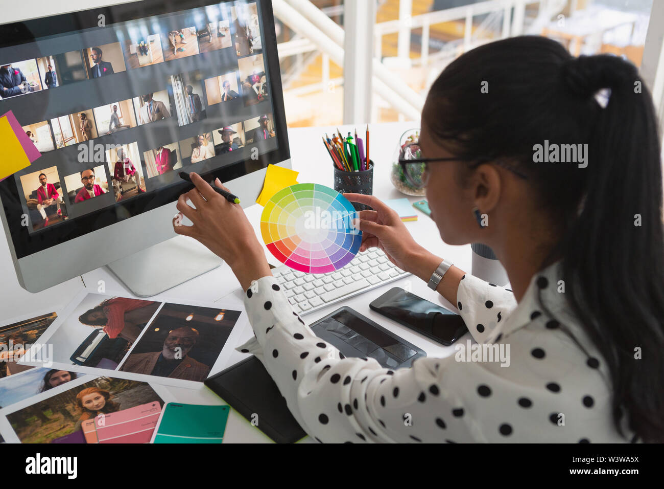 Female graphic designer working on computer at desk Stock Photo - Alamy