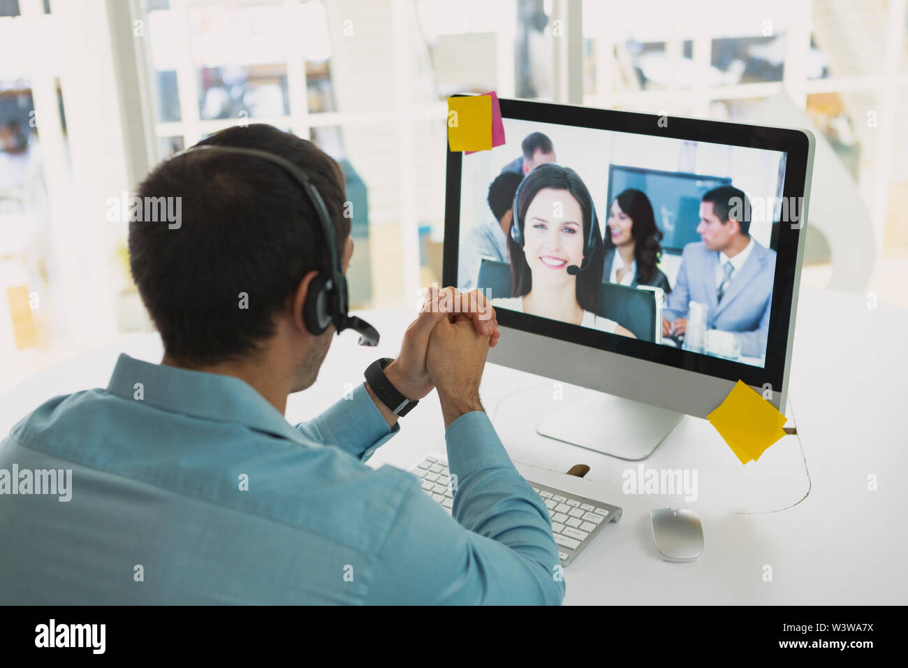 Male customer service executive making video call on computer at desk ...