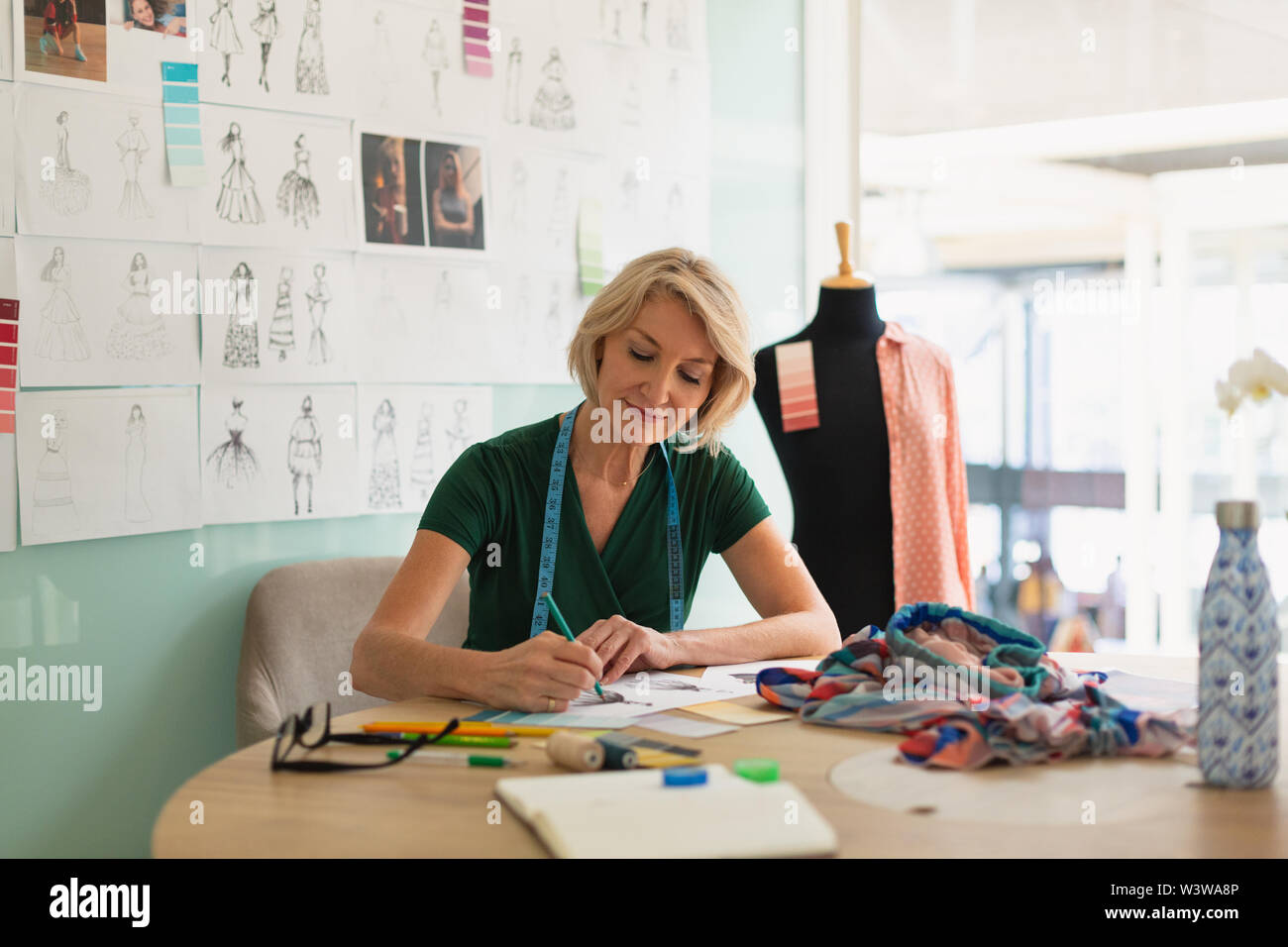 Female fashion designer drawing a sketch on a table Stock Photo - Alamy