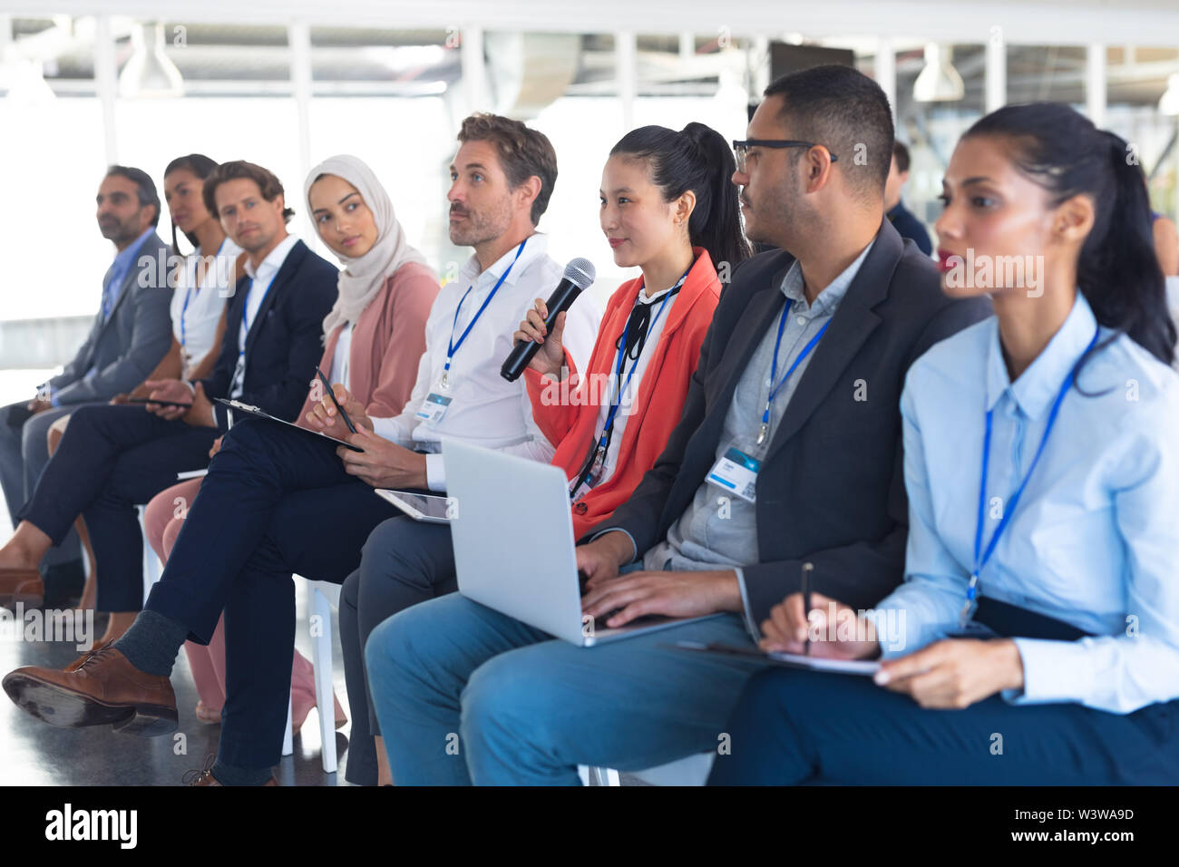 Businesswoman asking question during seminar Stock Photo - Alamy