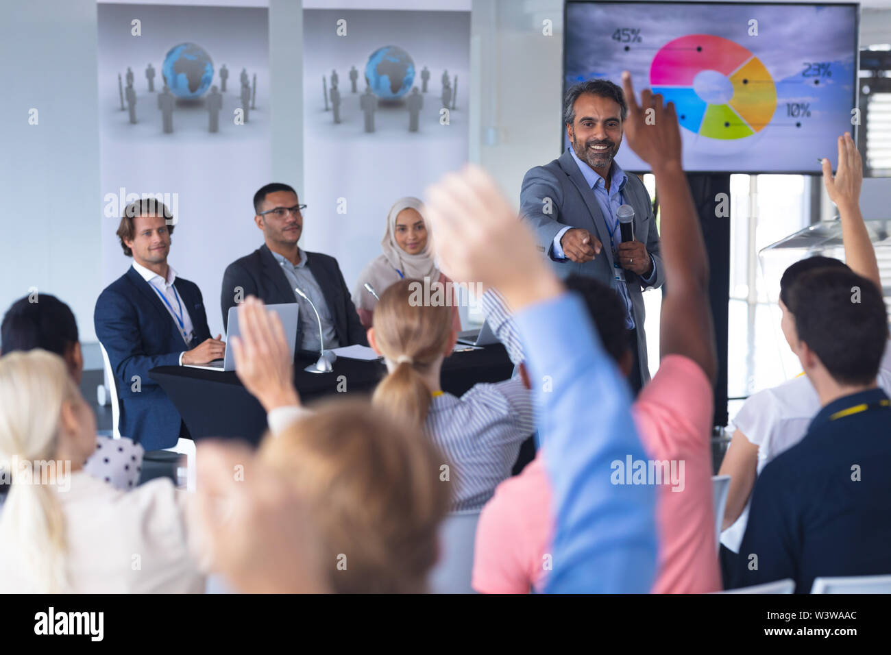 Audience raising their hands in a business conference Stock Photo - Alamy