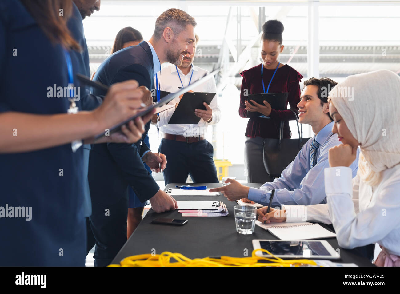 Business people checking in at conference registration table Stock ...