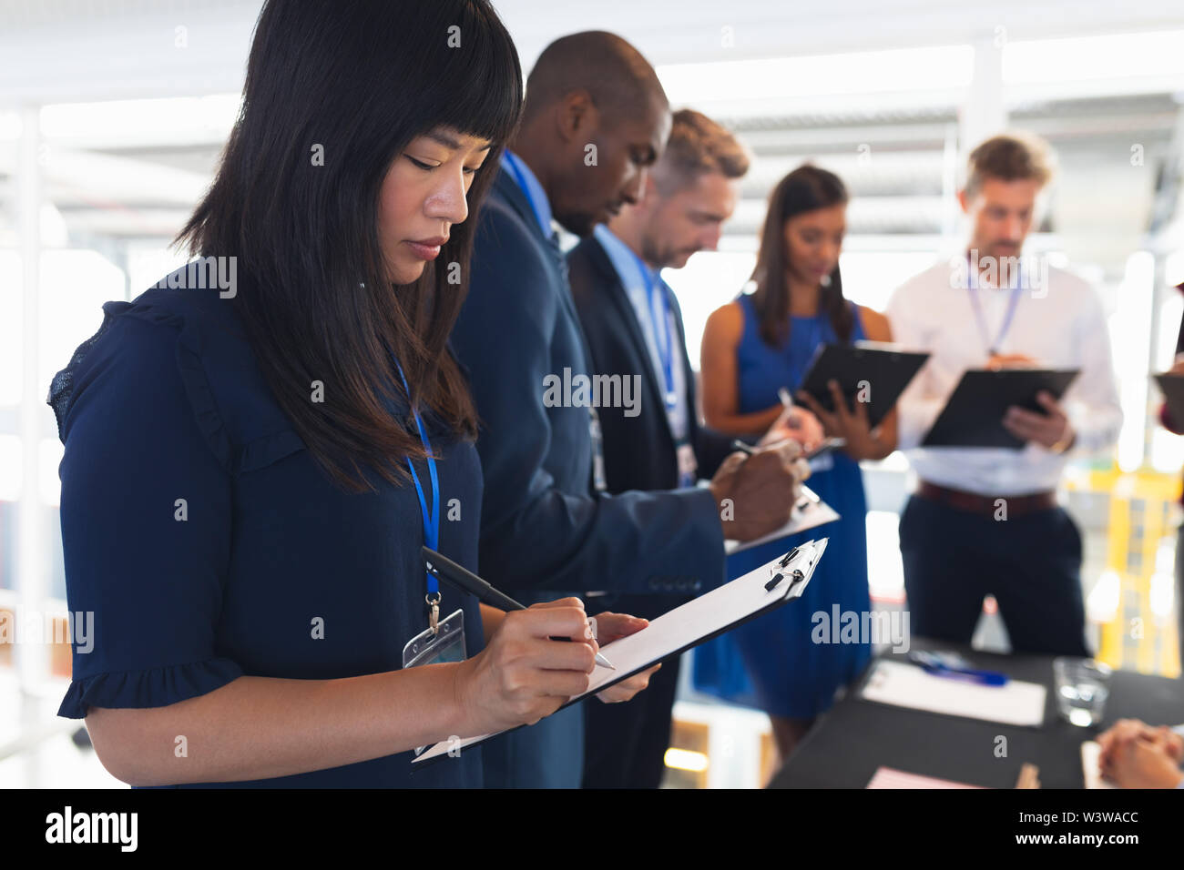 Business people checking in at conference registration table Stock ...