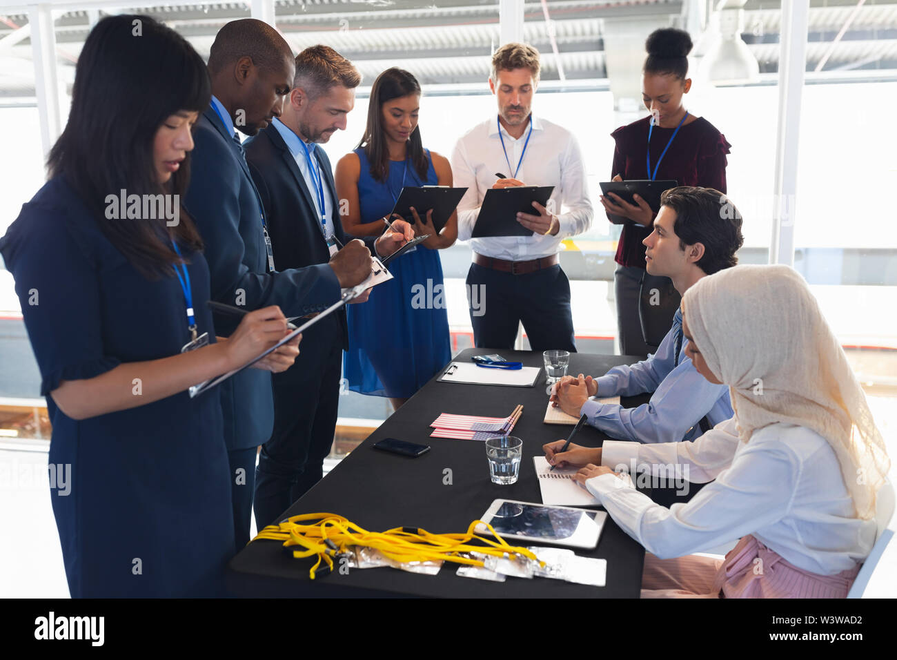 Business people checking in at conference registration table Stock ...
