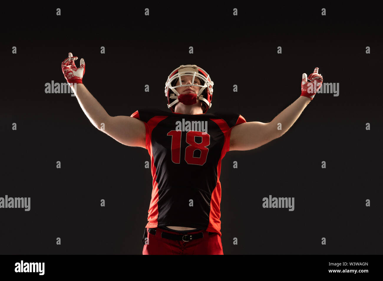 American football player standing against black background Stock Photo ...