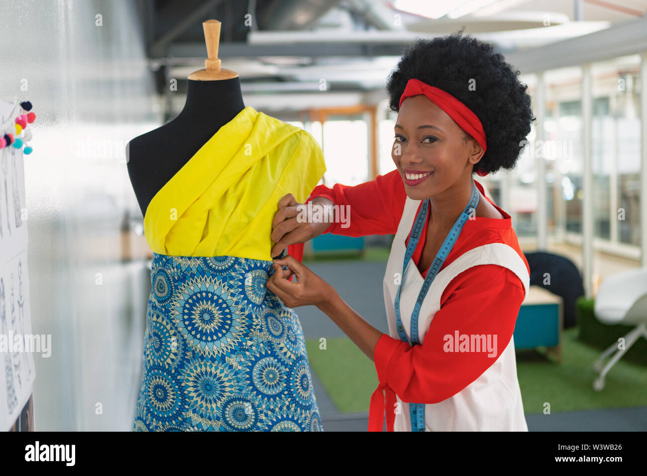 Female fashion designer dressing a mannequin in design studio Stock ...
