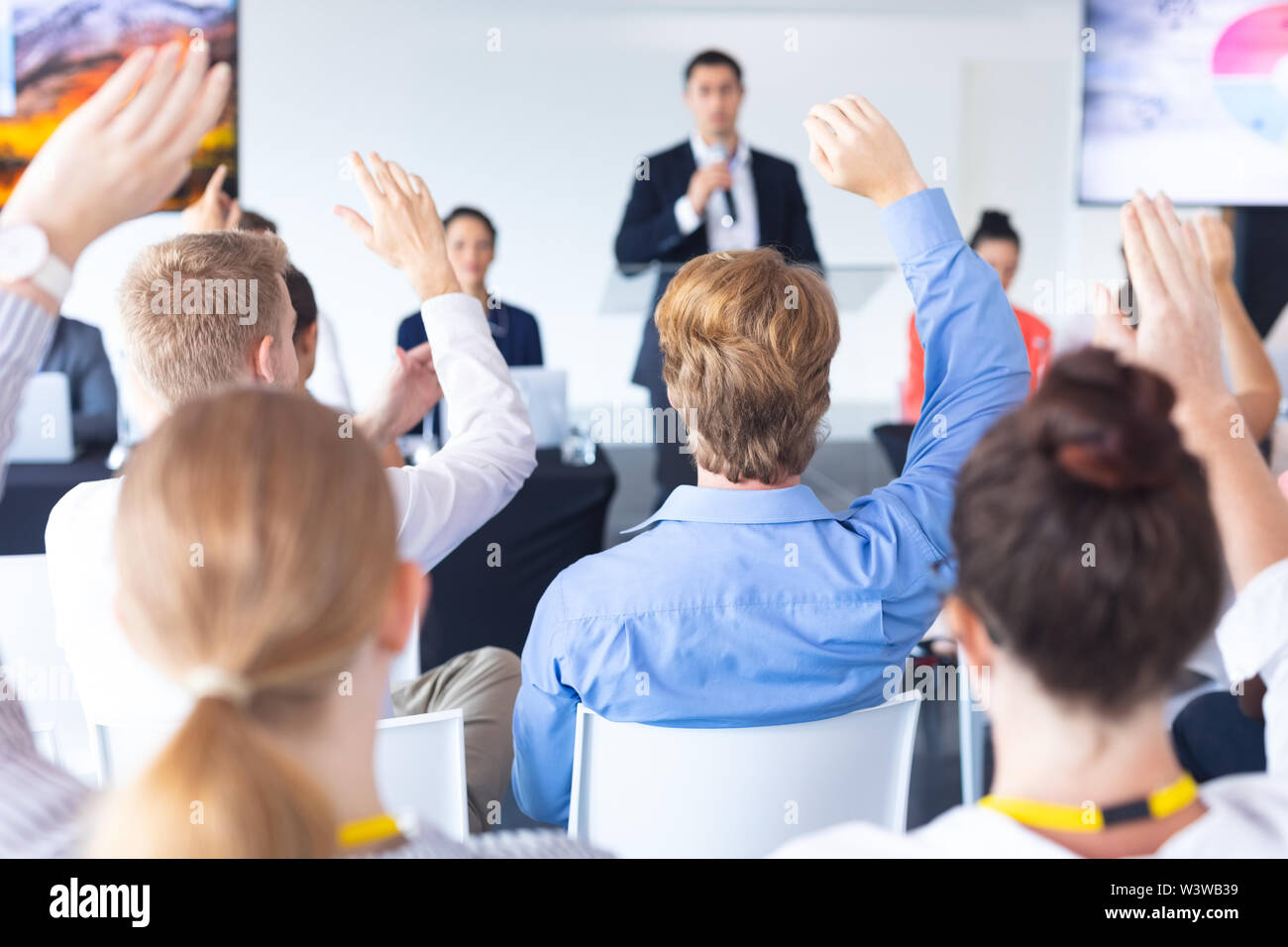 Audience raising their hands in a business conference Stock Photo - Alamy