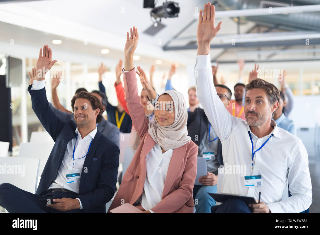 Audience raising their hands in a business conference Stock Photo - Alamy