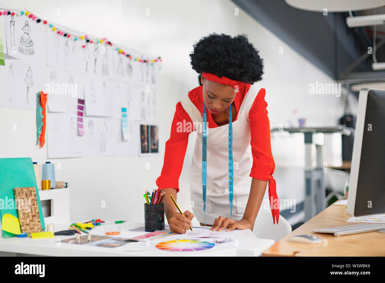 Female fashion designer drawing a sketch at desk Stock Photo - Alamy