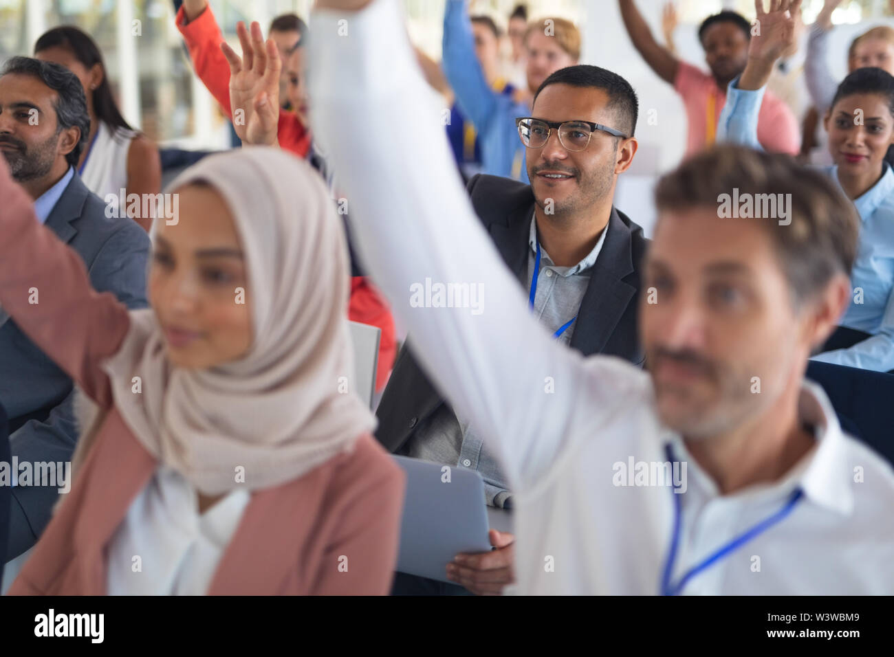 Audience raising their hands in a business conference Stock Photo - Alamy