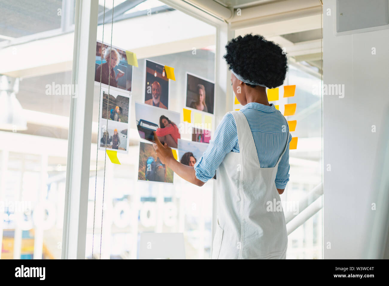 Female graphic designer checking photos in office Stock Photo - Alamy