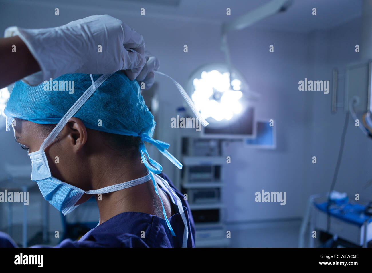 Female surgeon wearing surgical mask in operating room at hospital ...