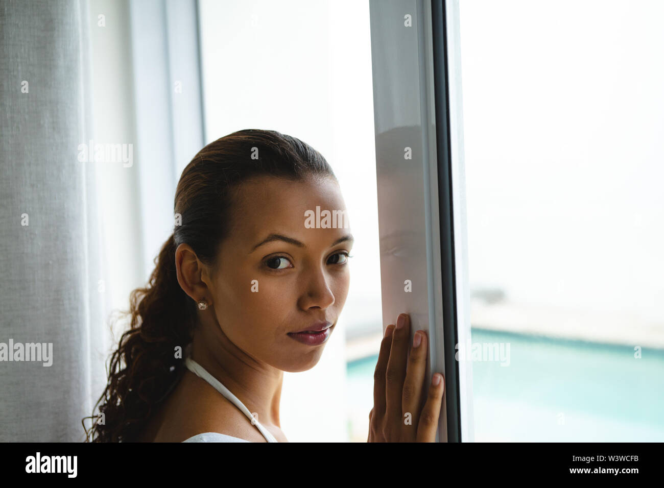 Woman standing near window in living room at home Stock Photo - Alamy