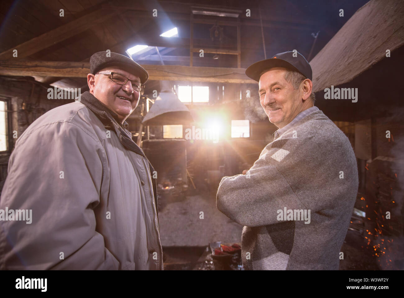 portrait of two confident senior blacksmith standing with crossed arms ...
