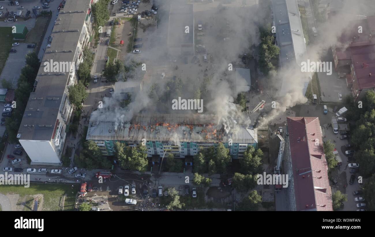 Burning roof of a residential high-rise building, clouds of smoke from ...