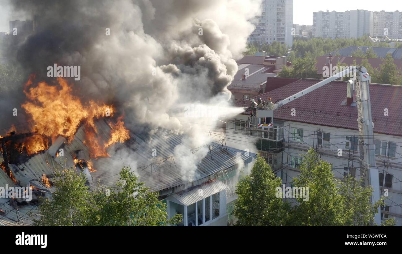 Burning roof of a residential high-rise building, clouds of smoke from ...