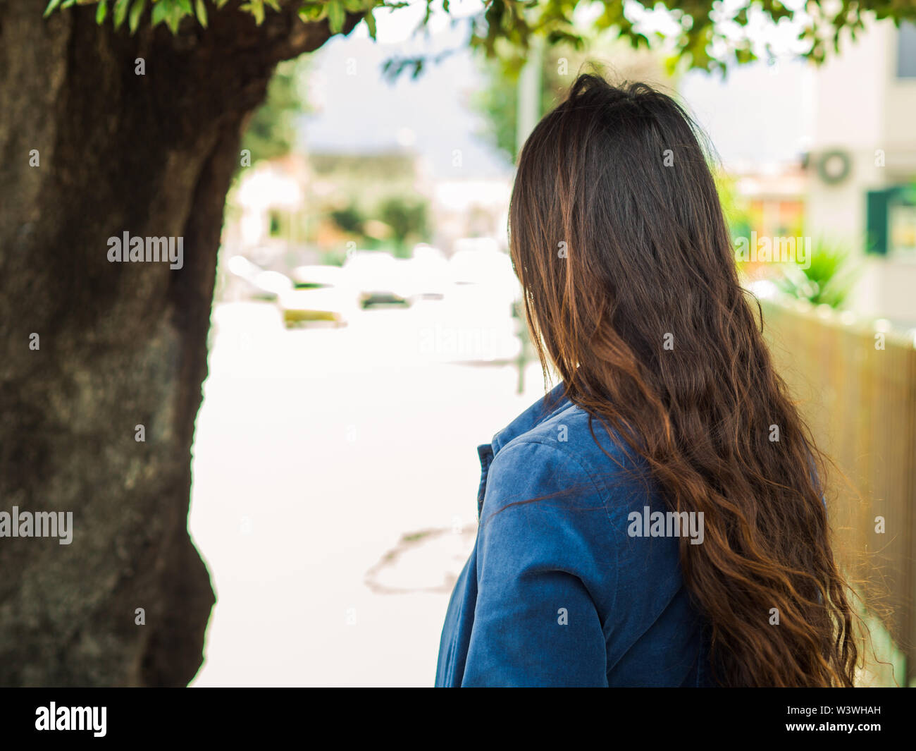 Authentic young woman outdoors turned with her back. Urban scene Stock ...