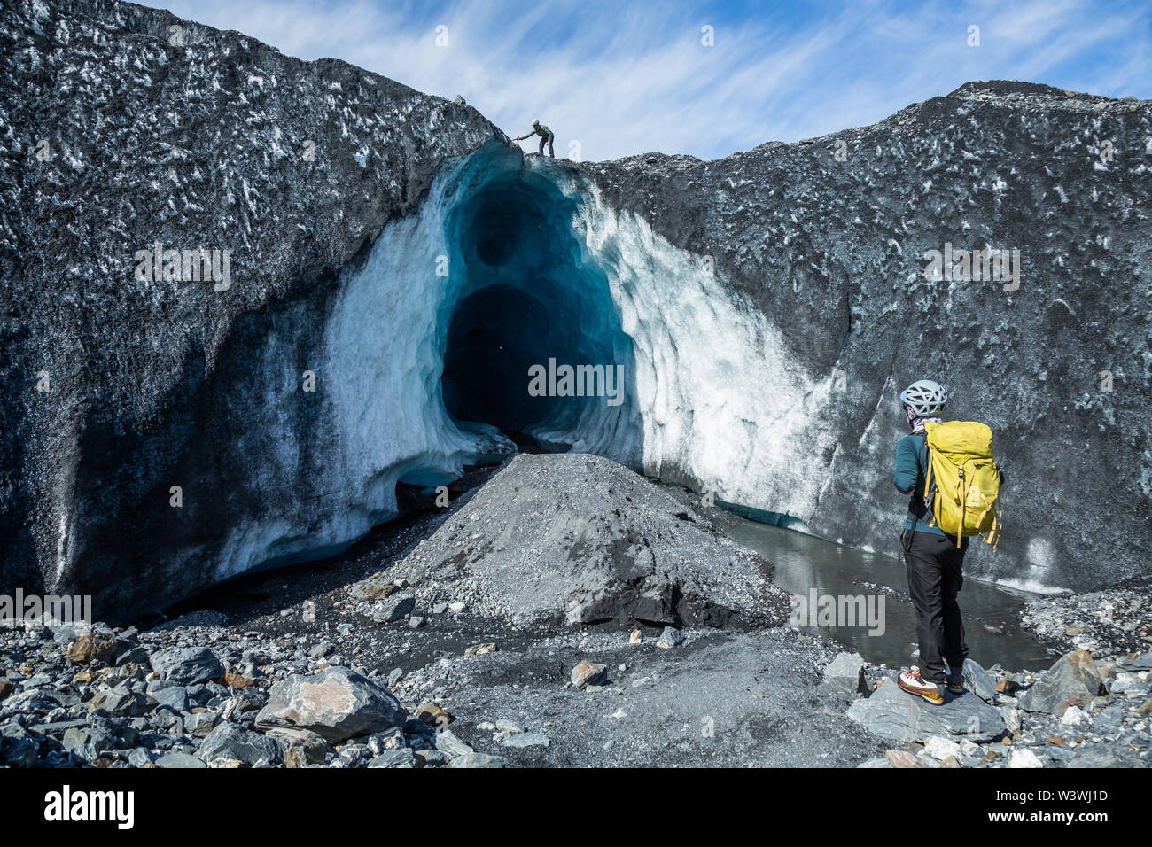 Two guides looking at a massive ice cave on the Matanuska Glacier in ...