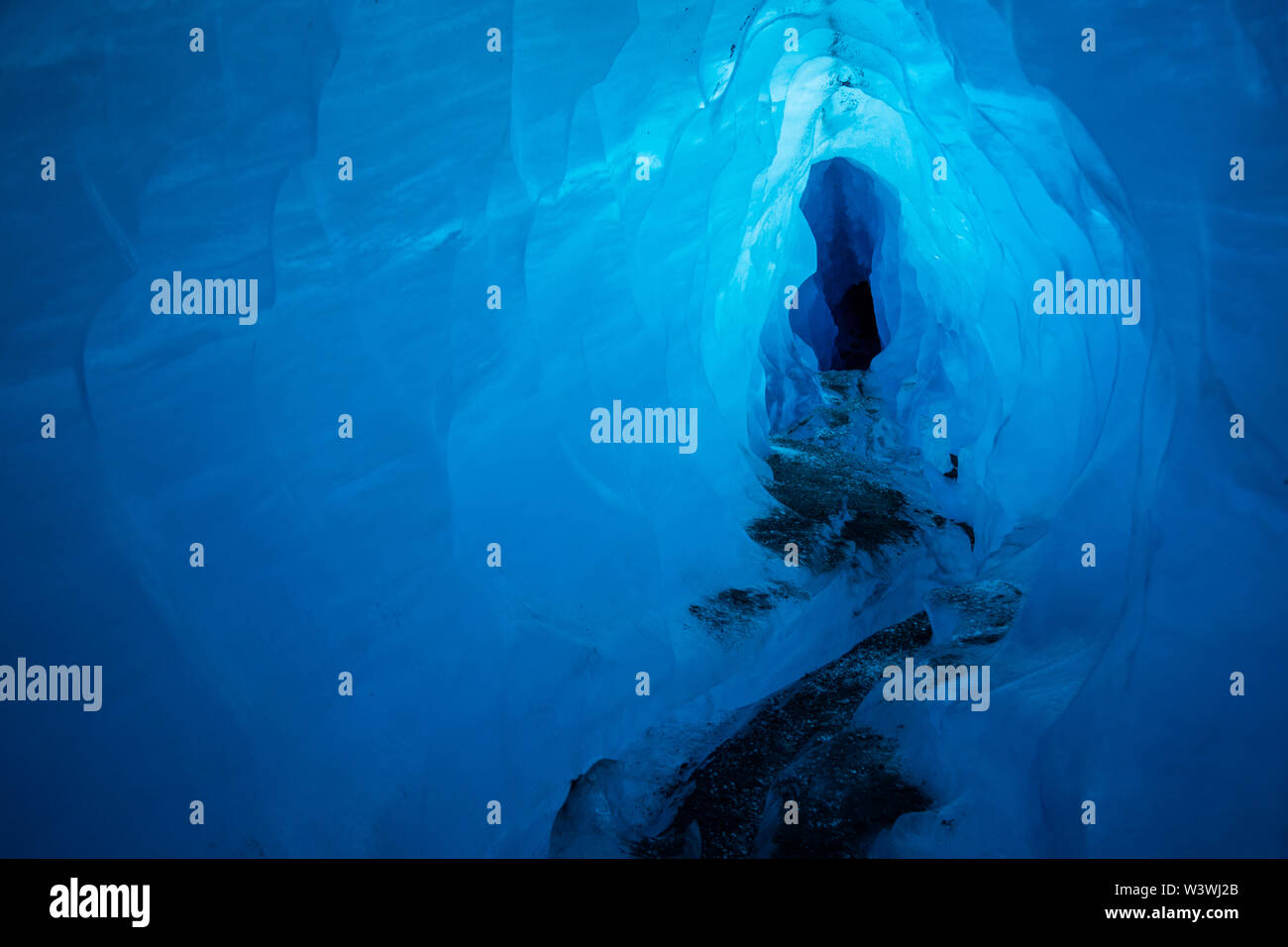 A horizontal tunnel carved into solid glacier ice by meltwater, this ...