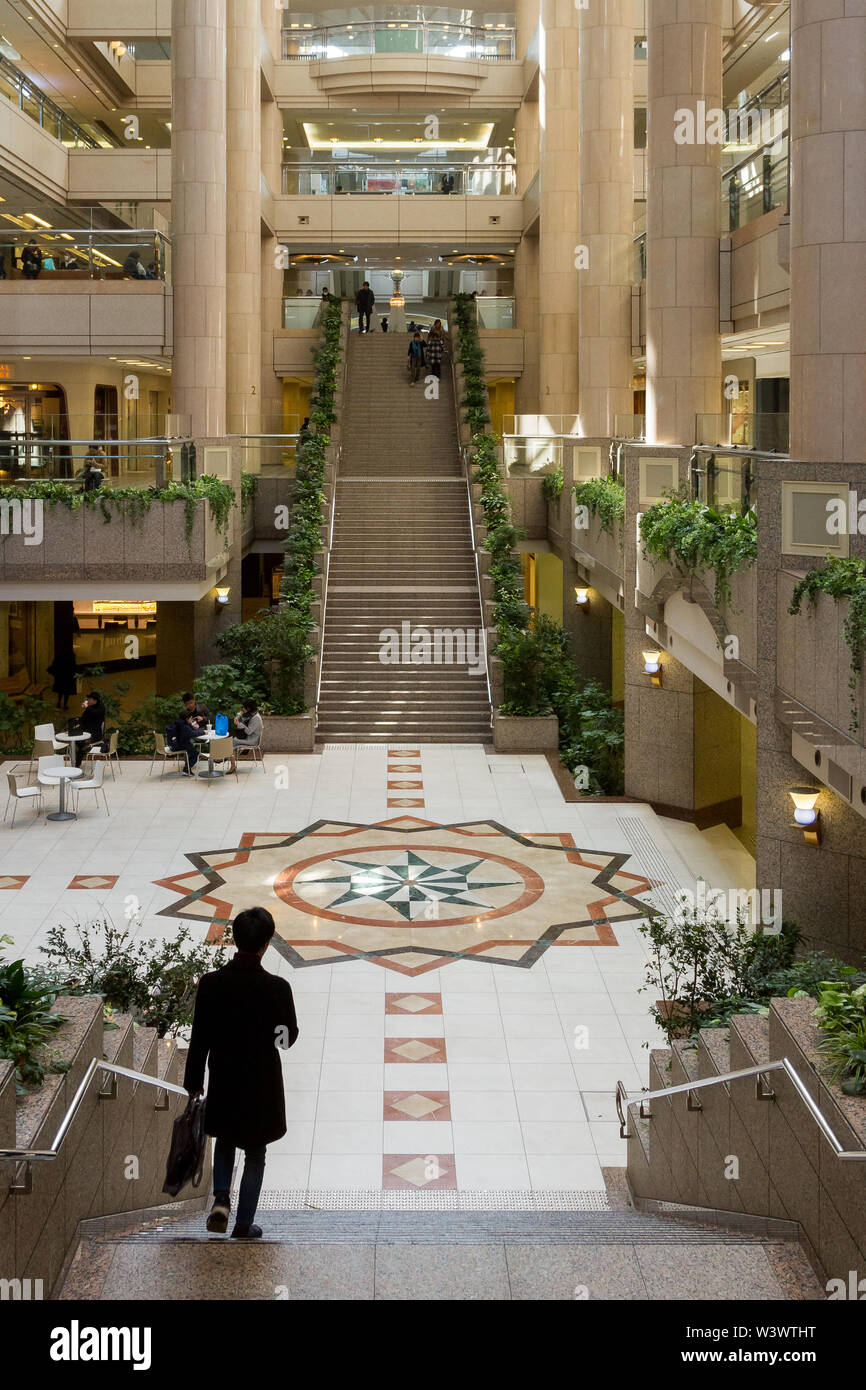 A man walks down stairs at Landmark Plaza under Landmark Tower ...