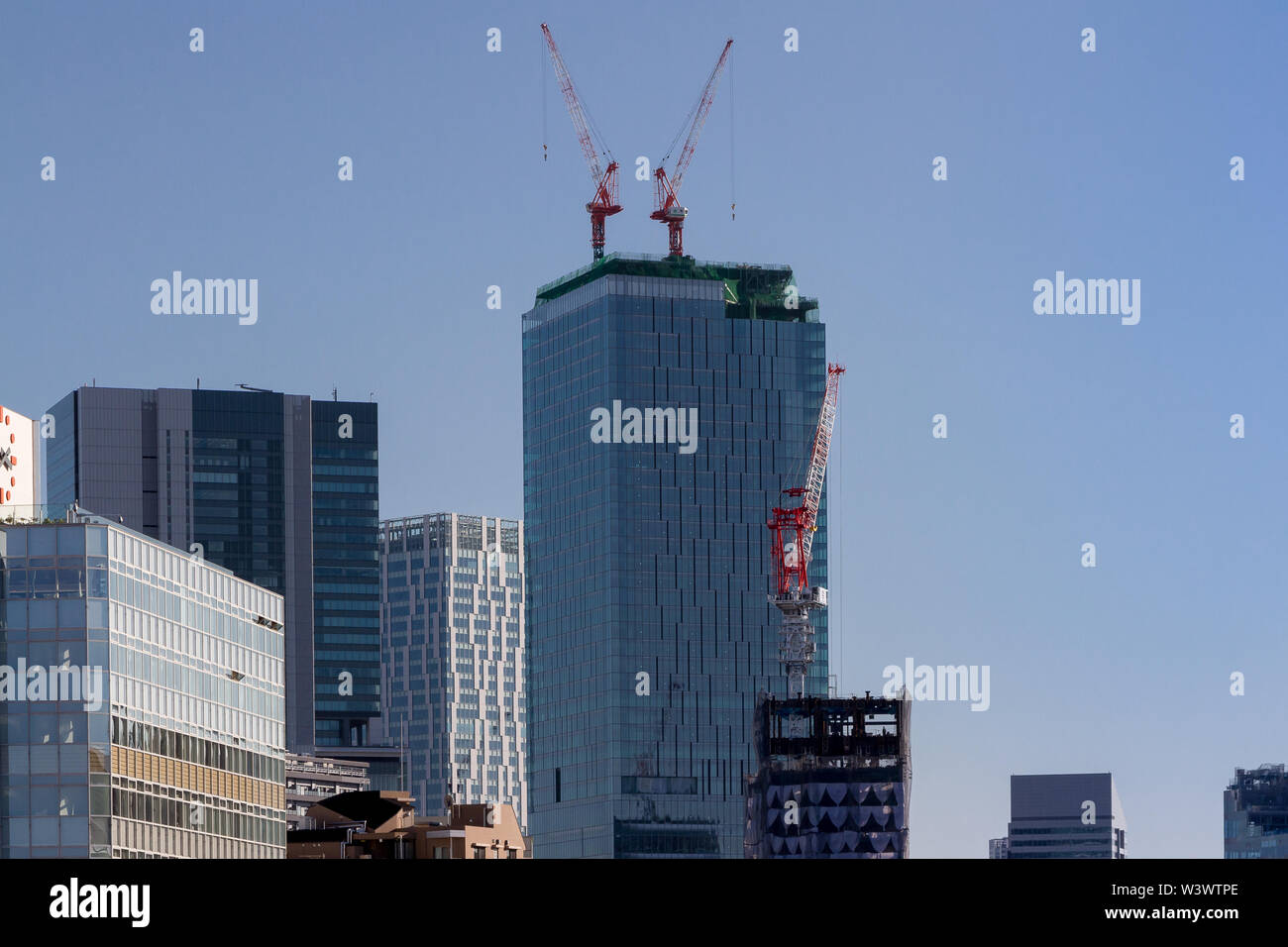 Cranes on the unfinished Shibuya Stream building and others that are ...