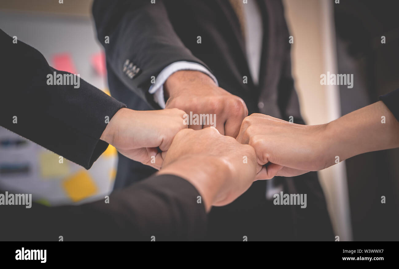 four Fist bump in business meeting for team concept Stock Photo - Alamy