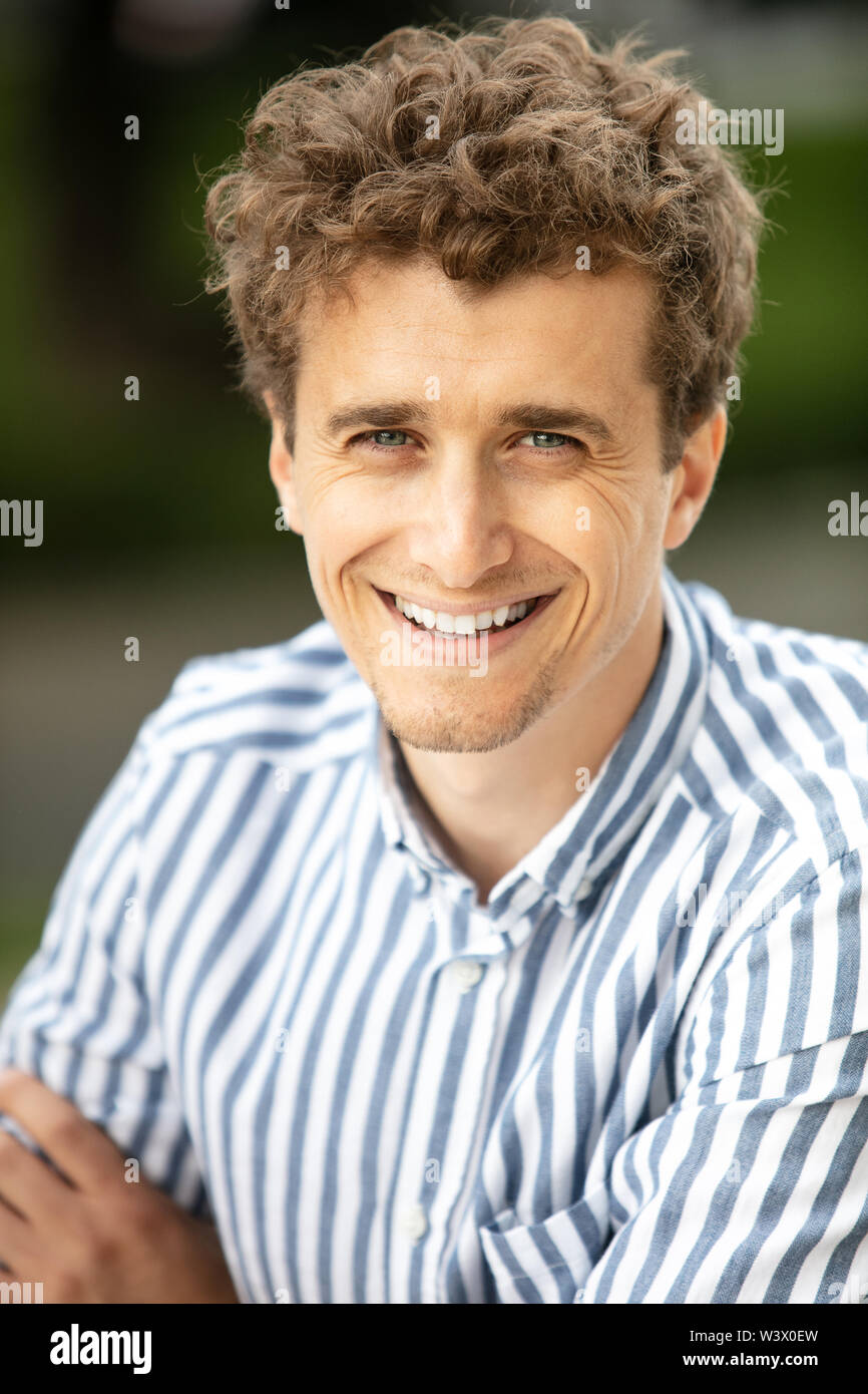 clouse up portrait of a young and confident man standing and looking to ...