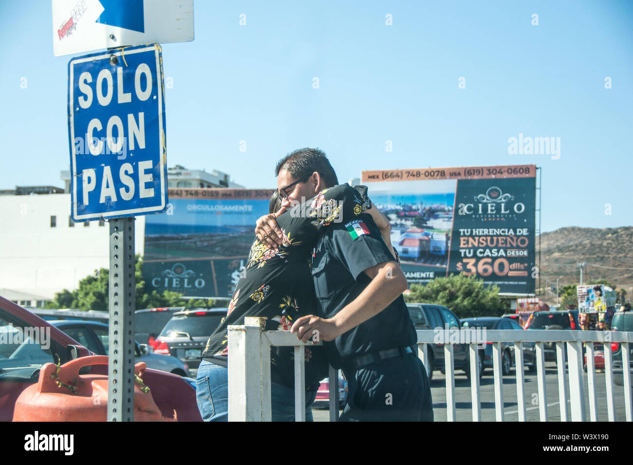 A woman giving a hug to a guard at the Mexico/USA border crossing Stock ...