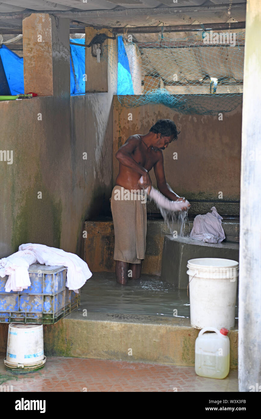 Indian man washing clothes and sheets at Dhobi khana public laundry in ...