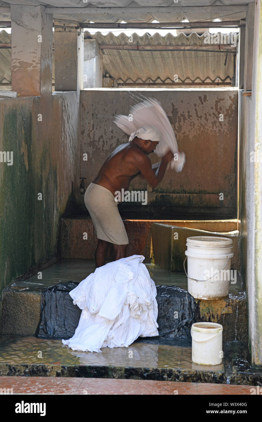 Indian man washing clothes and sheets at Dhobi khana public laundry in ...